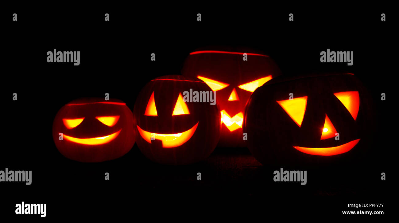Many Halloween Pumpkin glowing faces in a row on dark background Stock ...