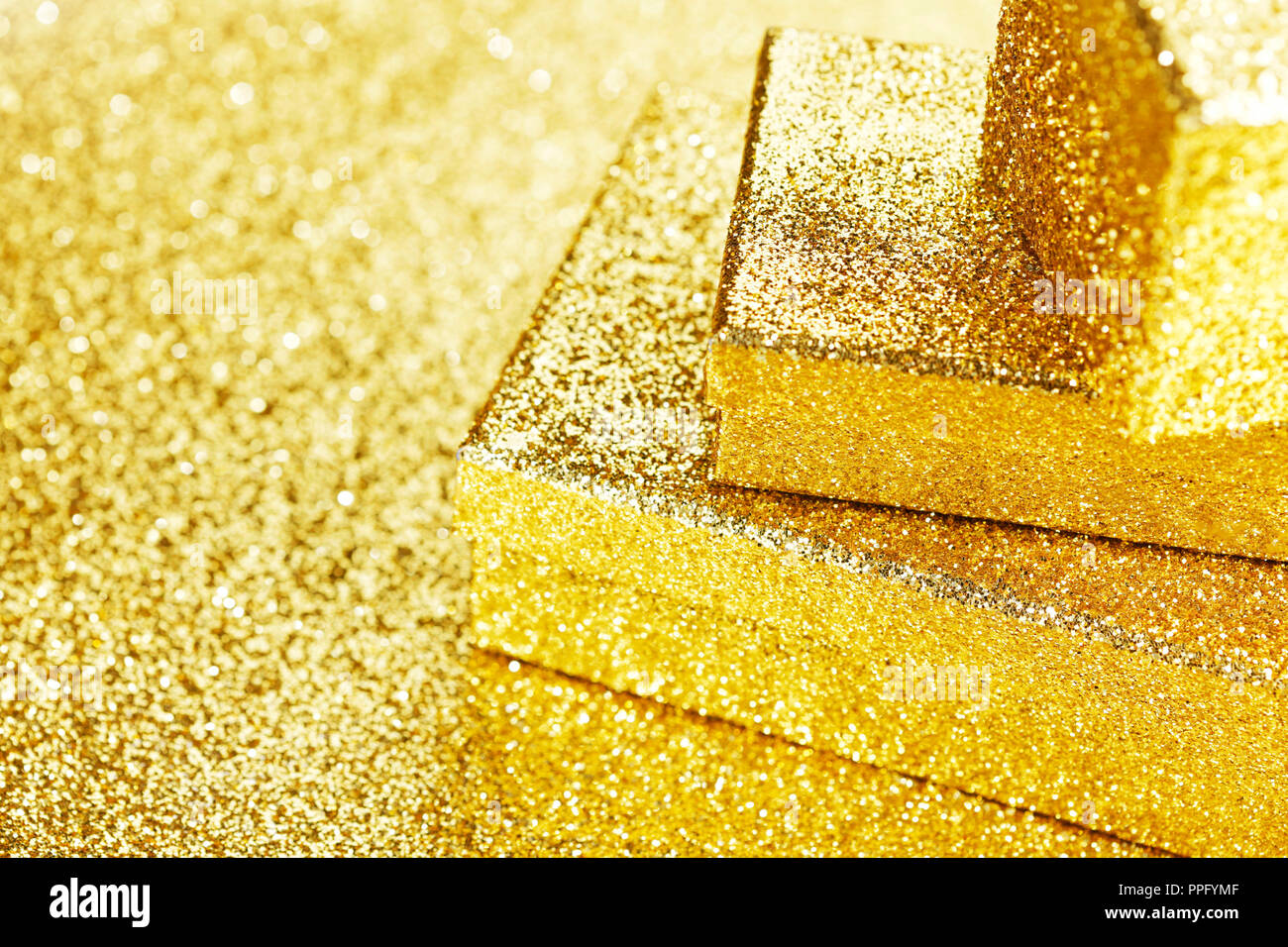 Decorative golden boxes with holiday gifts on shiny glitter background ...