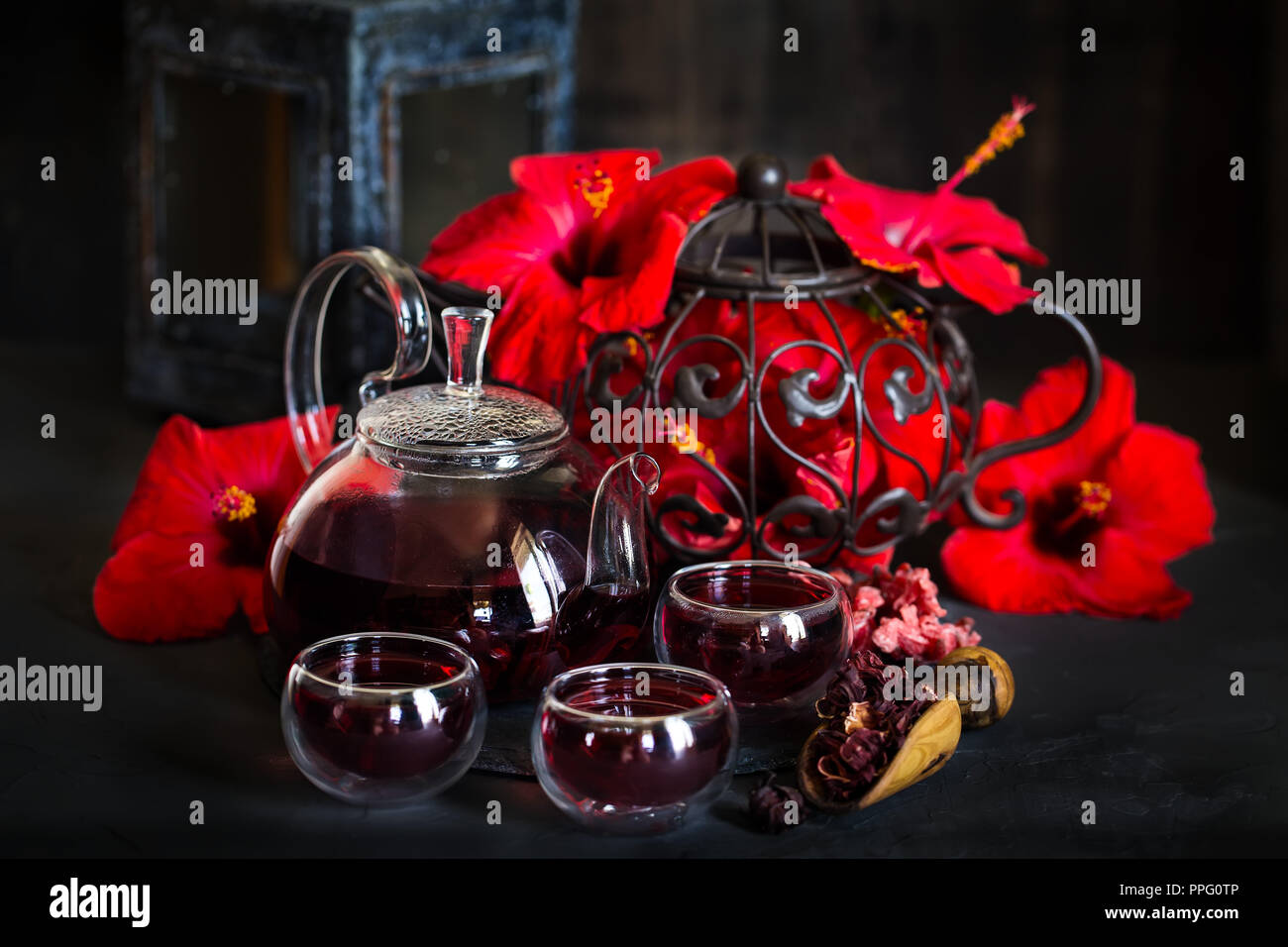 Herbal hibiscus tea carcade with red hibiscus flowers. Dark mood photo ...