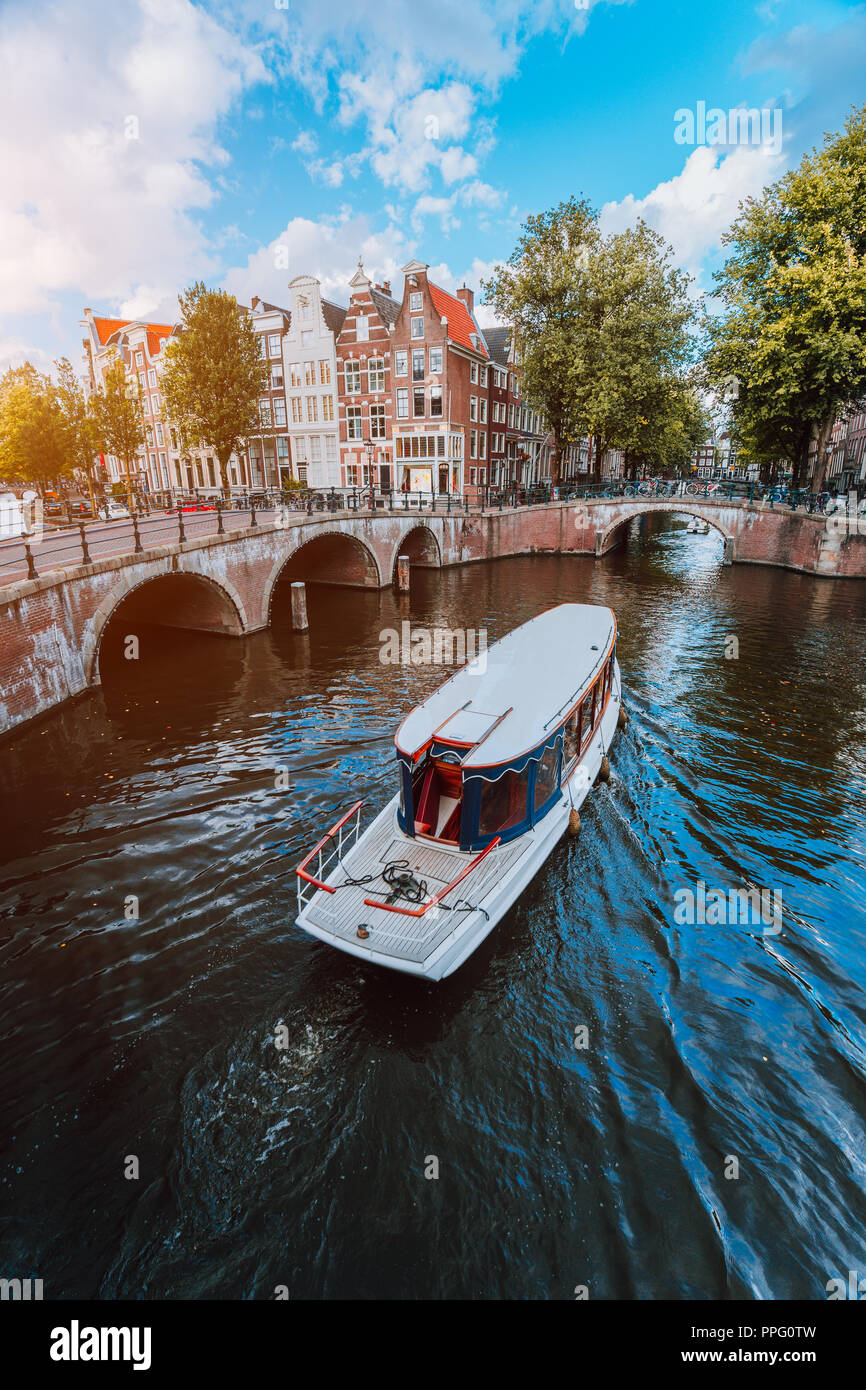 Tour boat at famous Dutch canal on a sunny day, traditional Dutch ...
