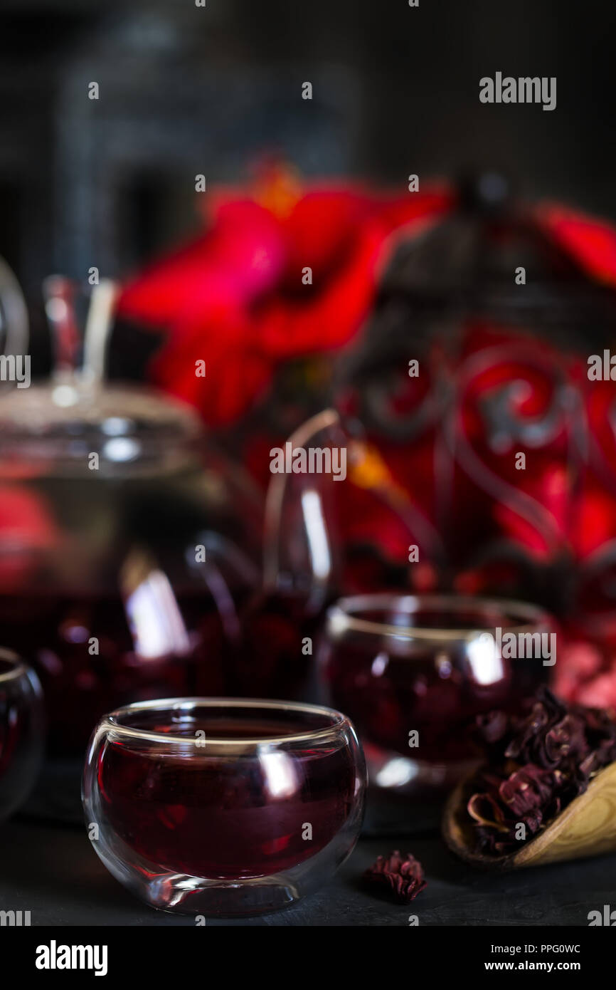 Herbal hibiscus tea carcade with red hibiscus flowers. Dark mood photo ...