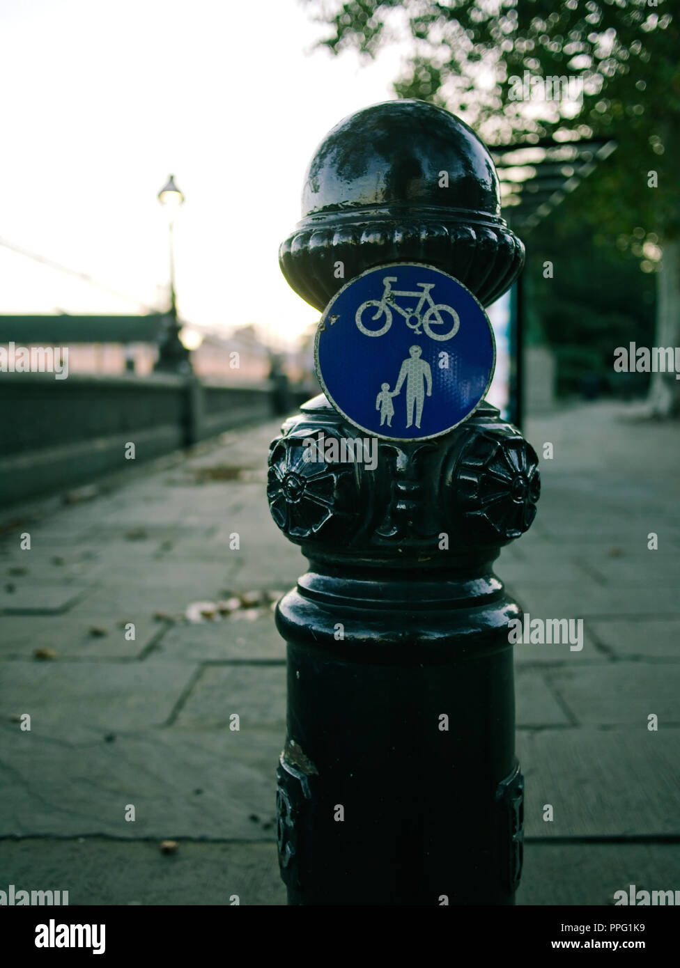Traditional British black bollard with road signs at a sidewalk Stock ...