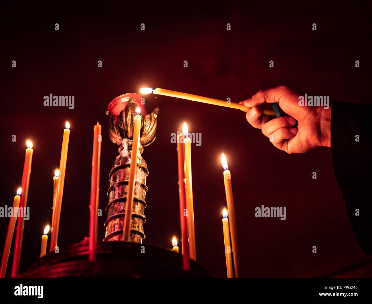 Hand lighting red candle match hi-res stock photography and images - Alamy