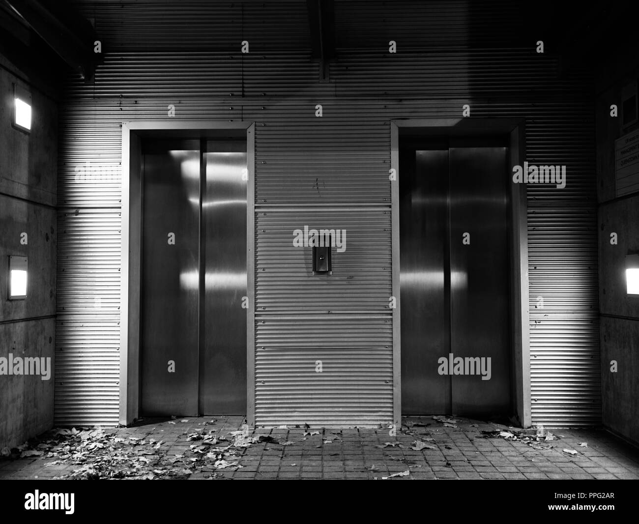 Black and white image of urban elevator doors and gray concrete walls ...