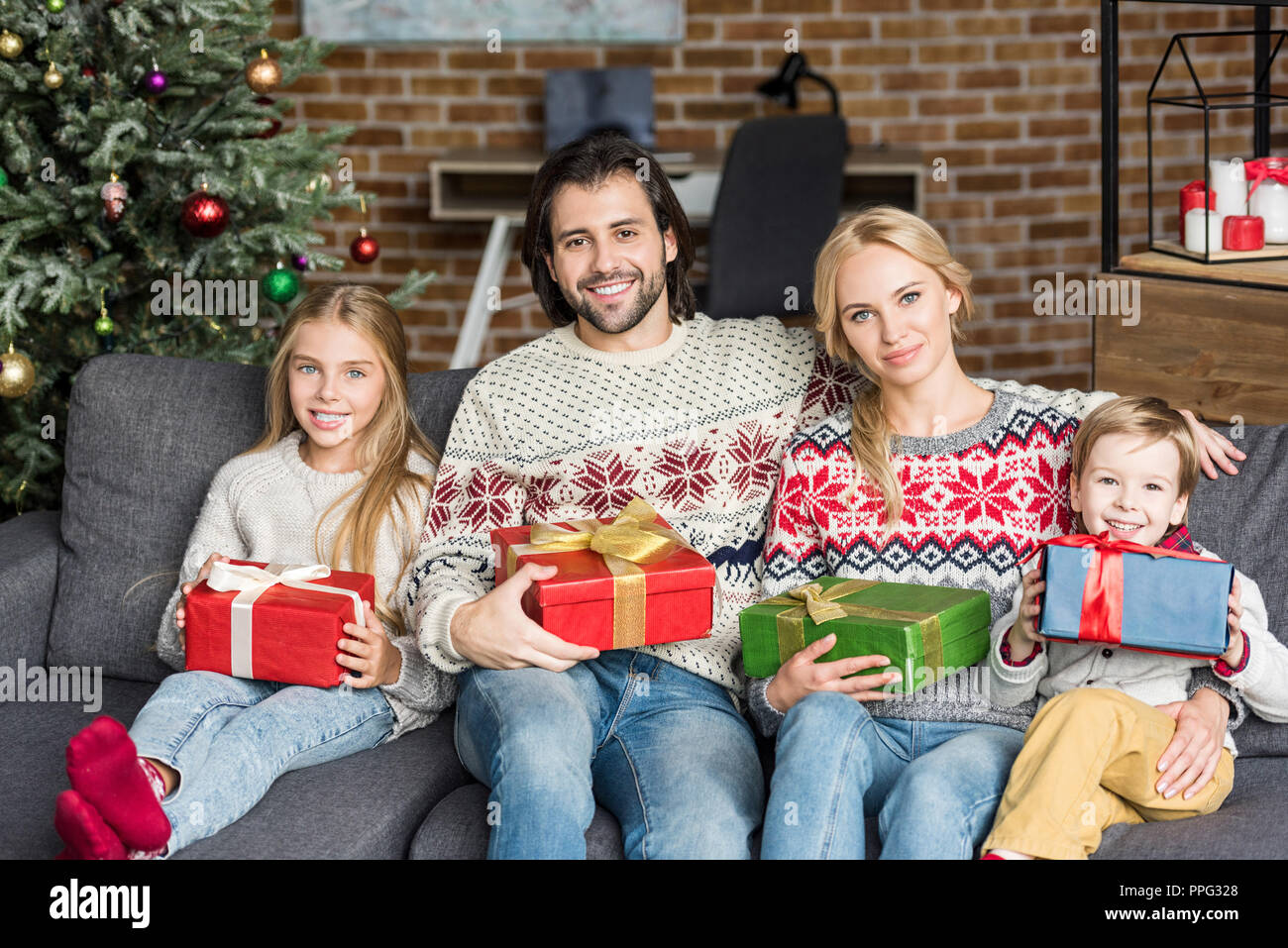 happy family with two children holding christmas presents and smiling ...