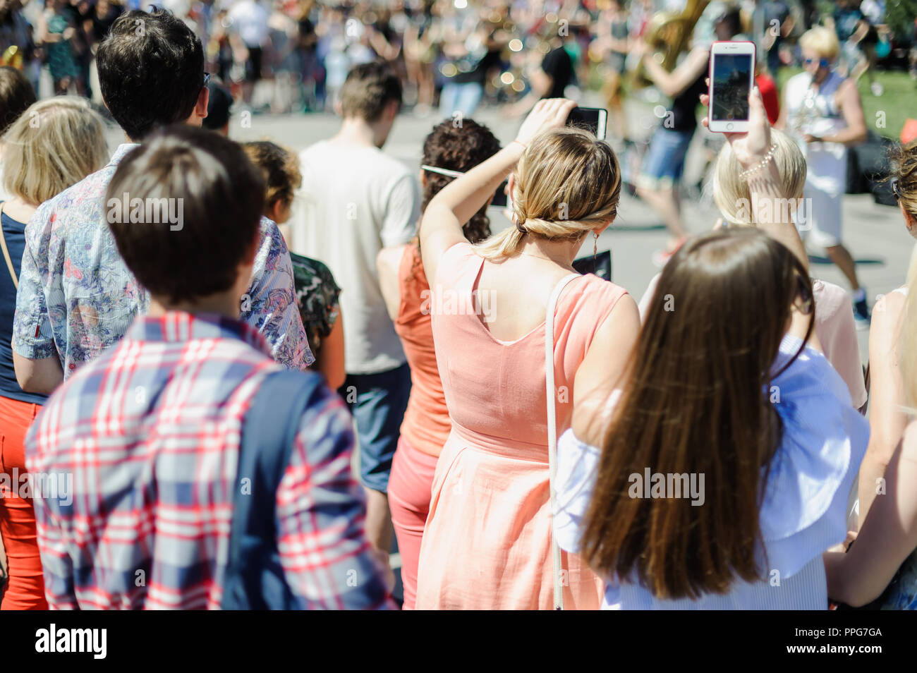 a crowd of citizens. many citizens on a city street, view from behind ...