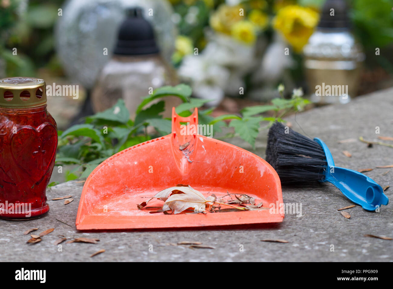 Cleaning grave on cemetery before All Saints' Day Stock Photo - Alamy