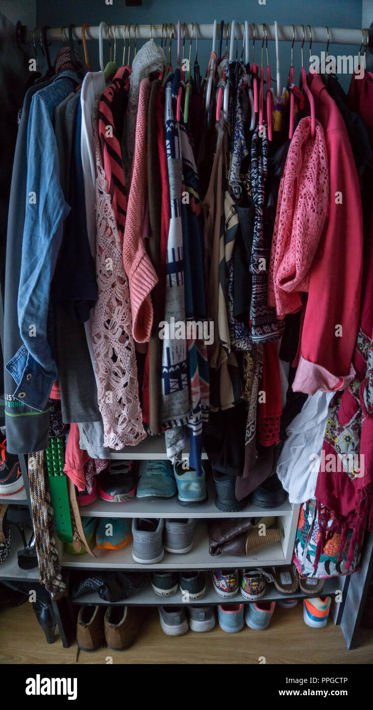 Unorganized hanging rack personal female closet with all kind of shits ...