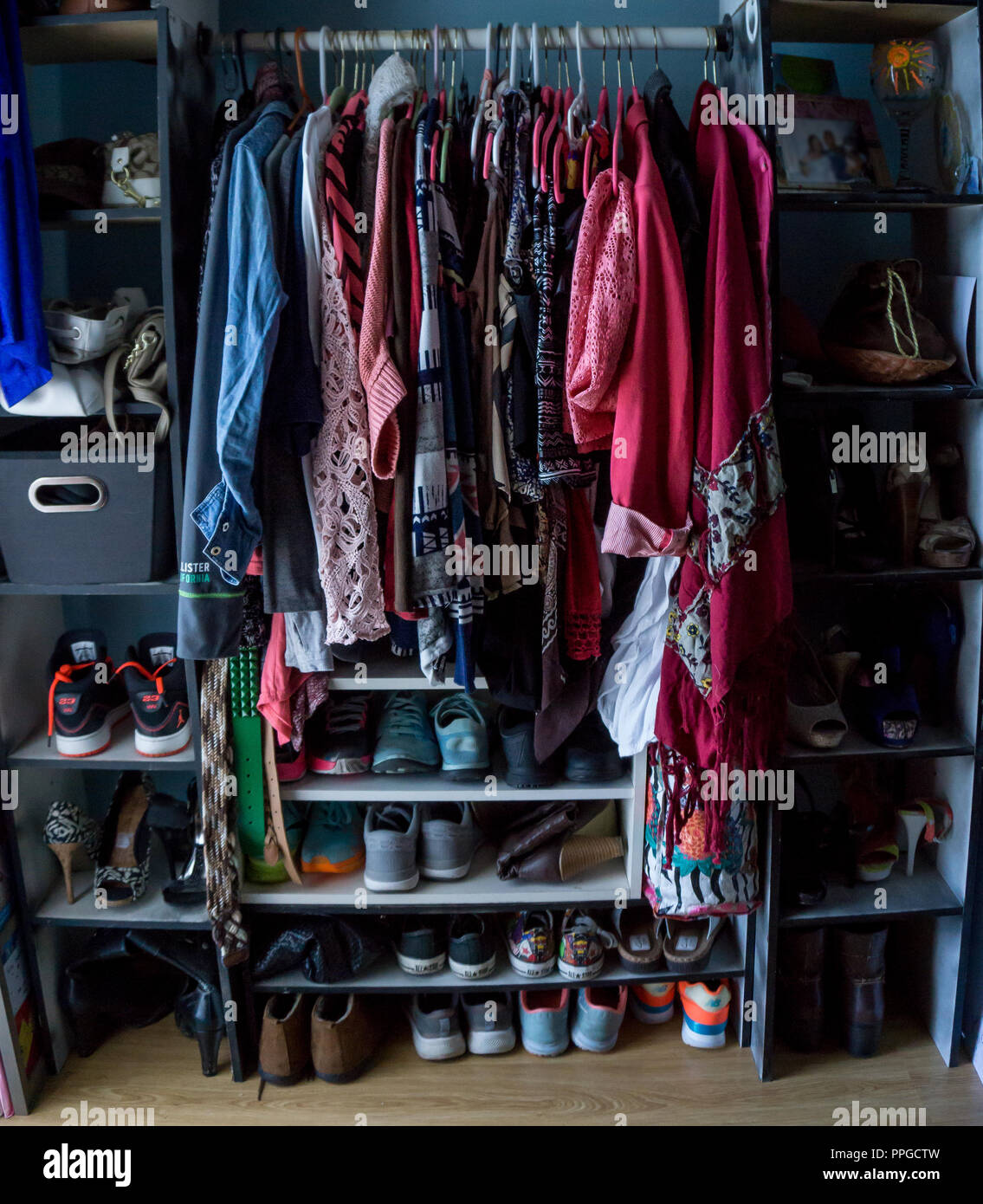 Unorganized hanging rack personal female closet with all kind of shits ...