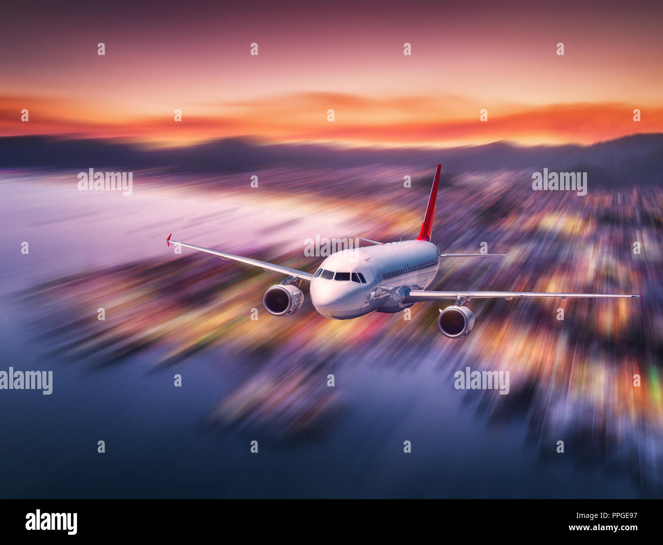 Airplane with motion blur effect is flying over sea coast at night ...