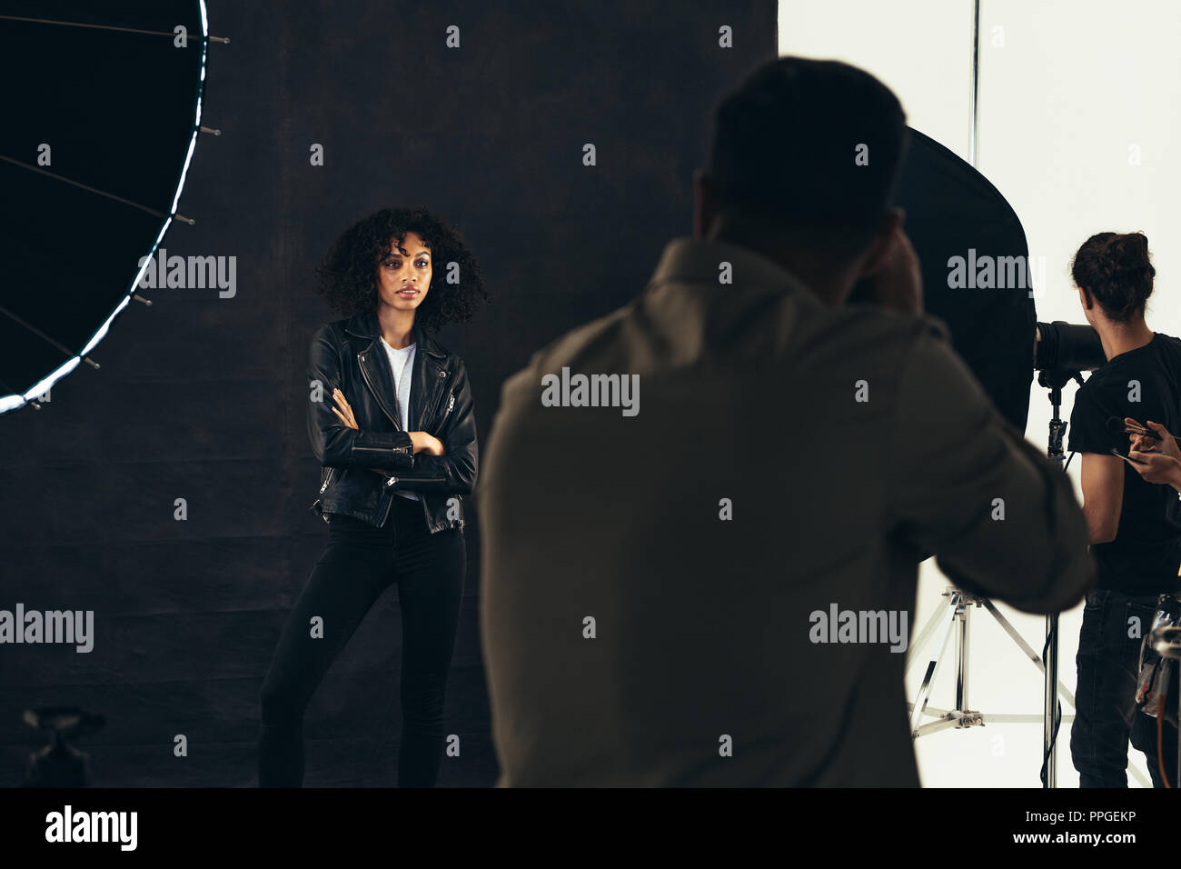 Rear view of a photographer taking photos of female model. Photographer ...