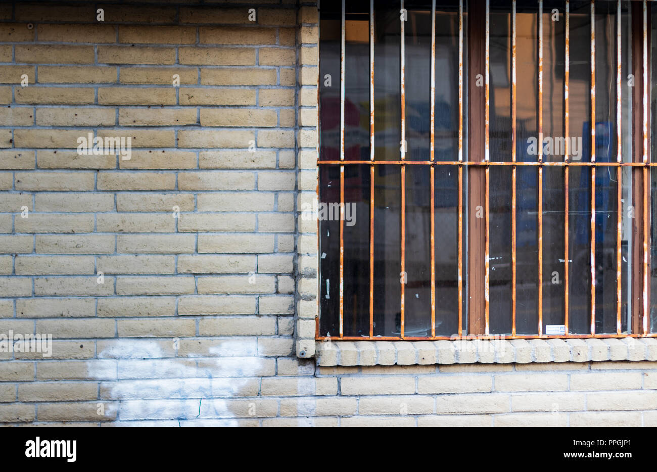 Old abandoned building window with rusty bars and deteriorated brick ...