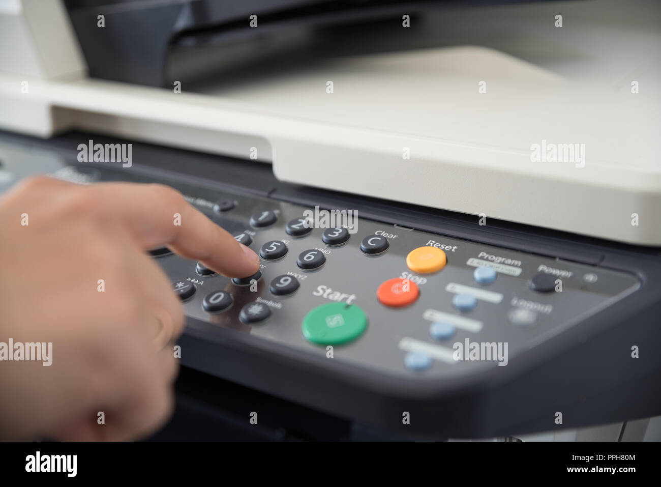 Office worker works with multi-function device and sets the number of ...