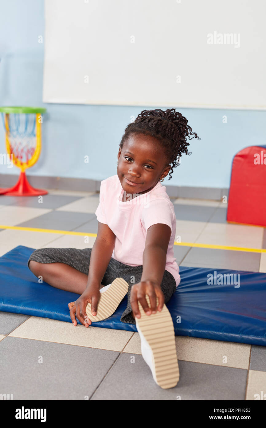 African girl in childrens gymnastics does an exercise to healthy ...