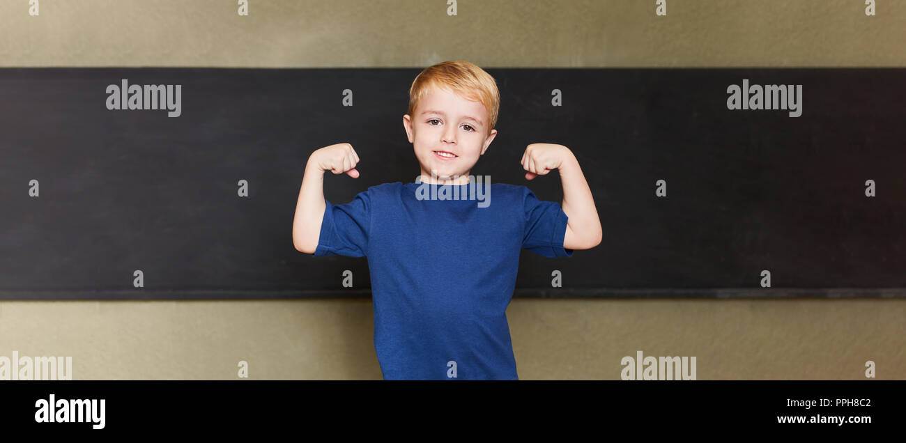 Proud strong student shows his muscles in front of a blackboard in ...
