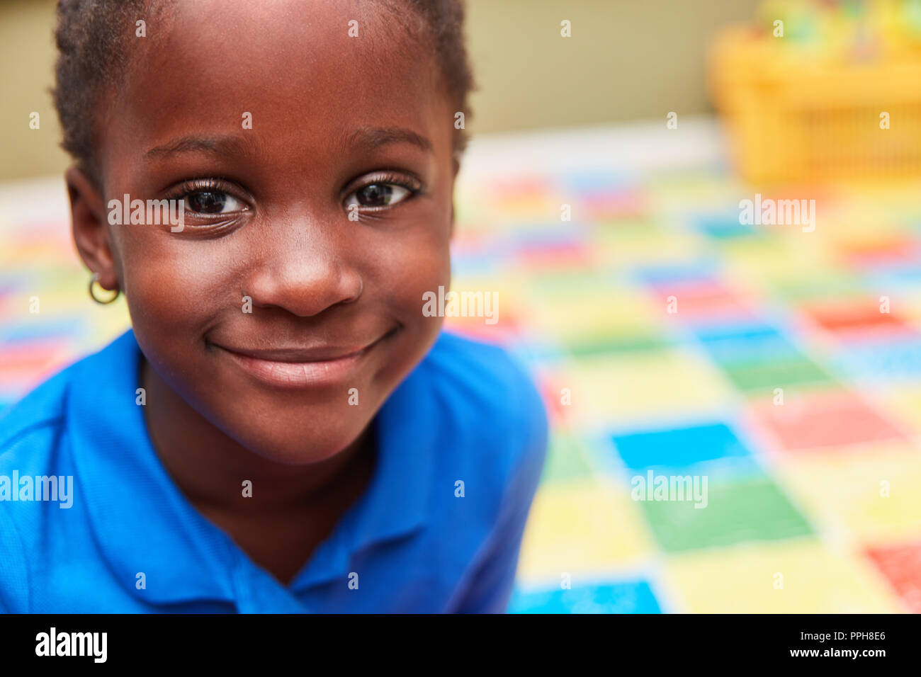 Smiling african girl in kindergarten or elementary school as a pupil ...