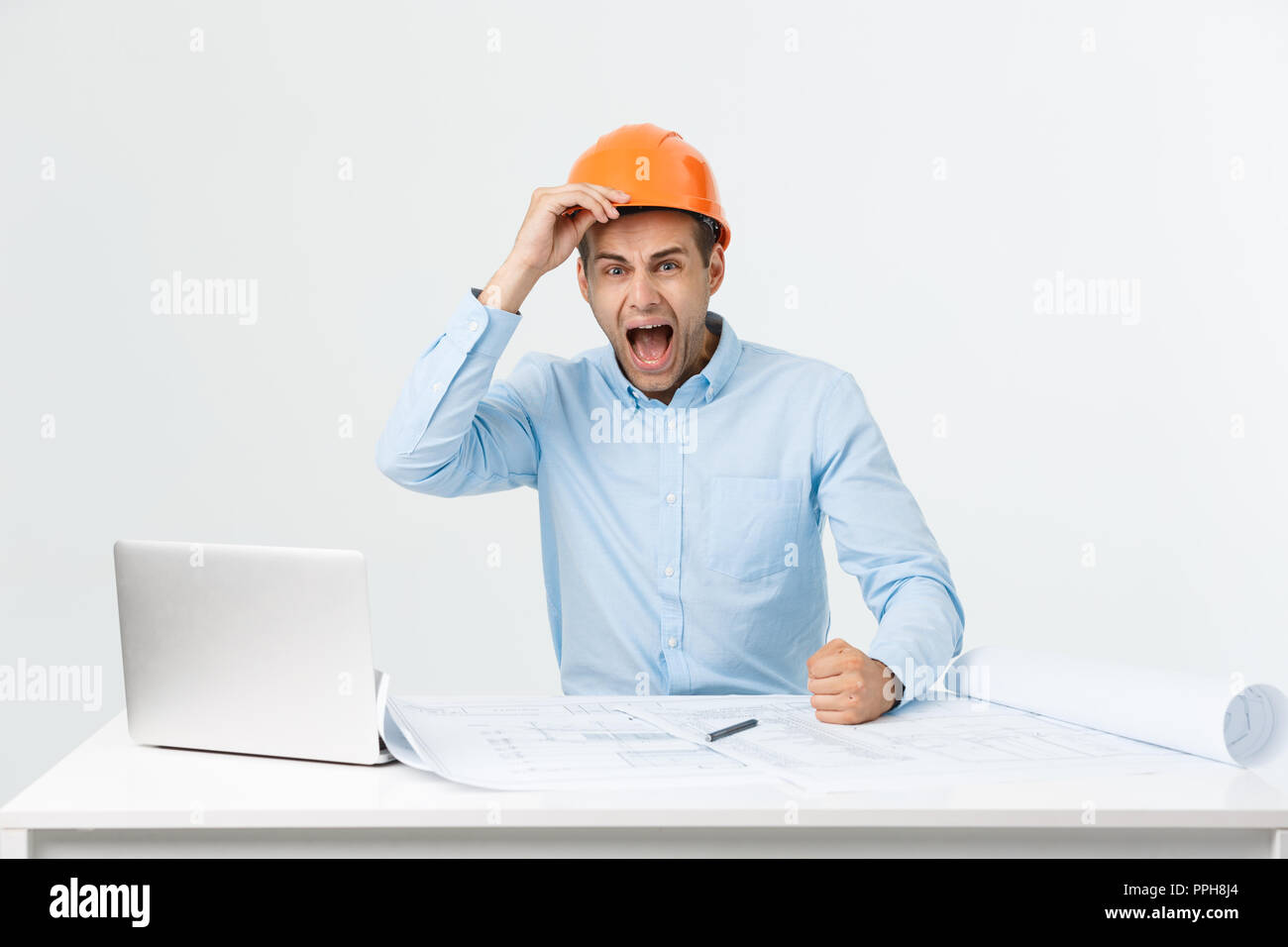 Young Engineer angry during working with laptop in office building site ...