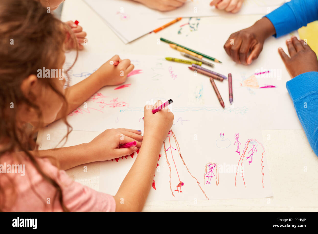 Children in a painting class in kindergarten draw with crayons creative ...