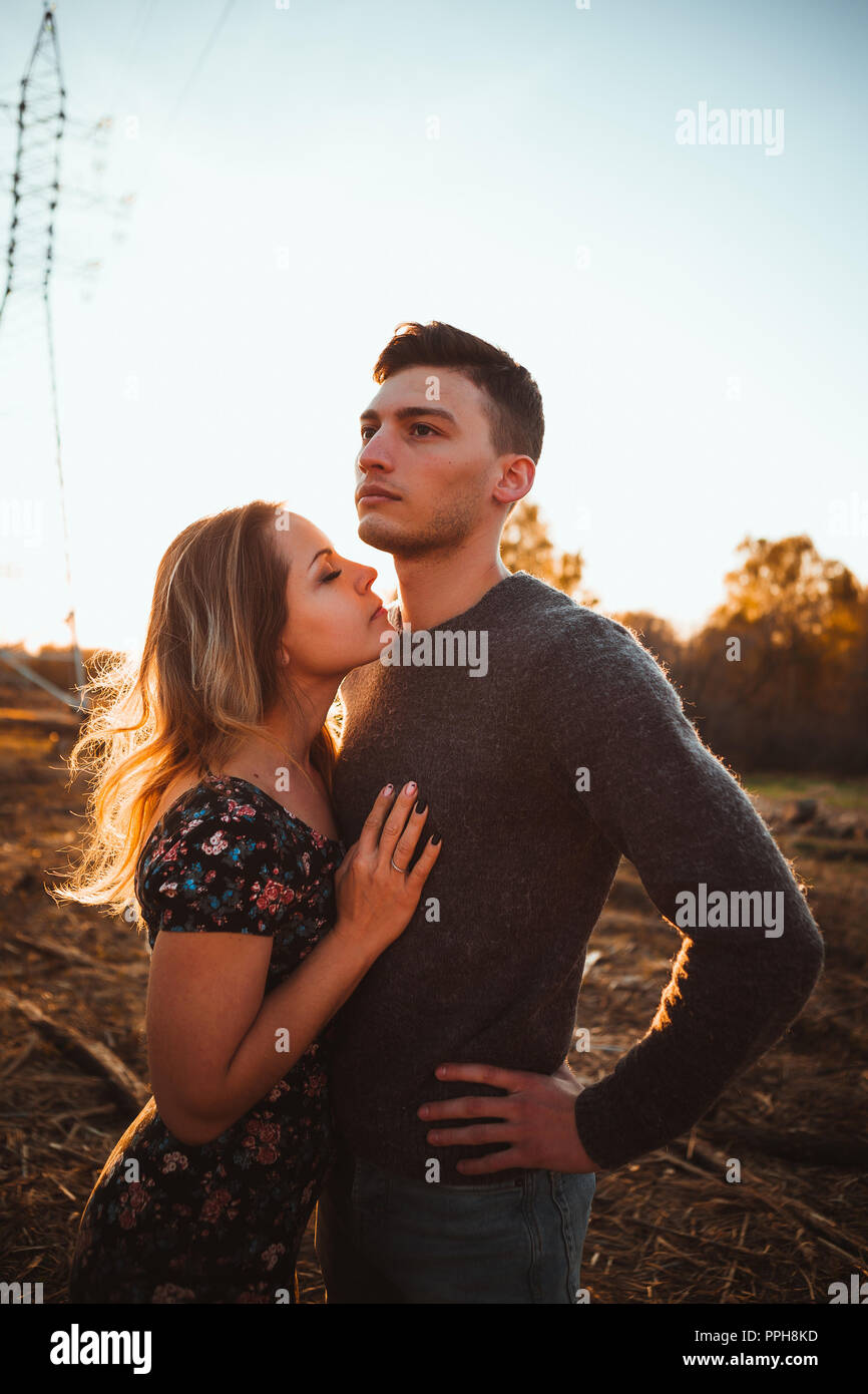 guy and girl in the field on the sunset background Stock Photo - Alamy