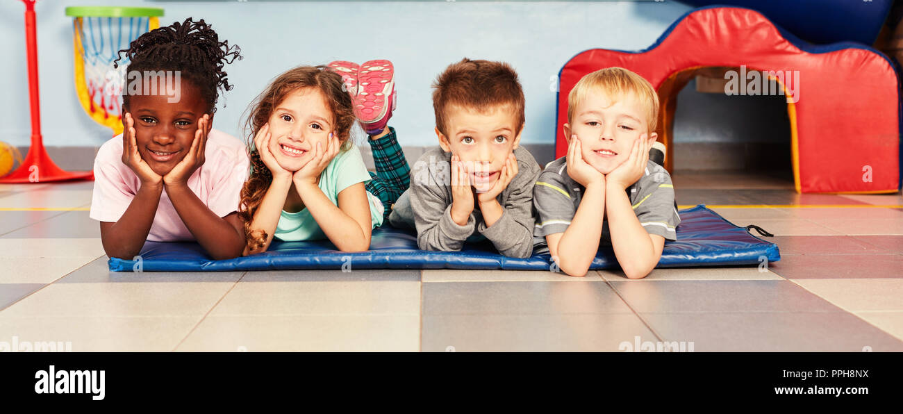 Happy children are lying on a mat during a kid's gymnastics in the ...