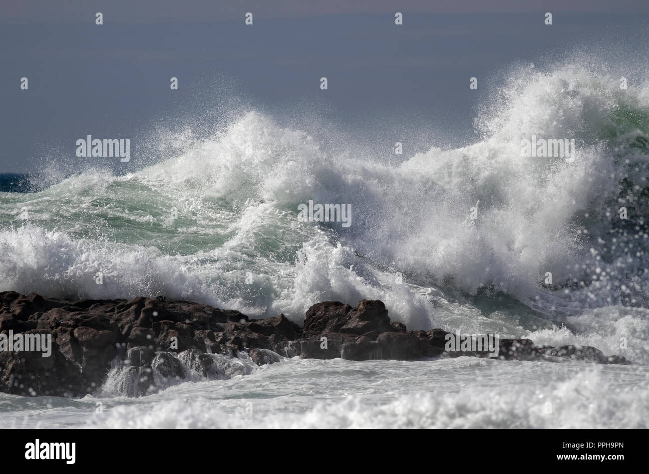 Big green wave breaking over rocky coast. Northern Portugal Stock Photo ...
