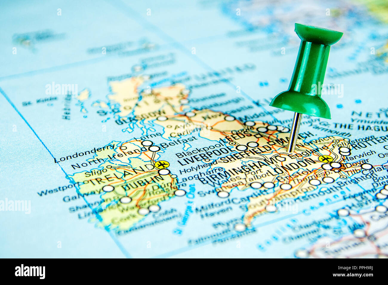 closeup of draw-pin stick into real map, travelling to SGreat Britain ...