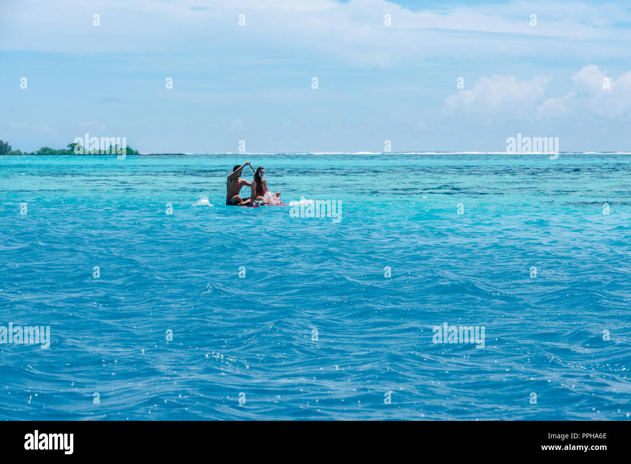 Moorea, French Polynesia--March 18, 2018. A couple navigates the aqua ...