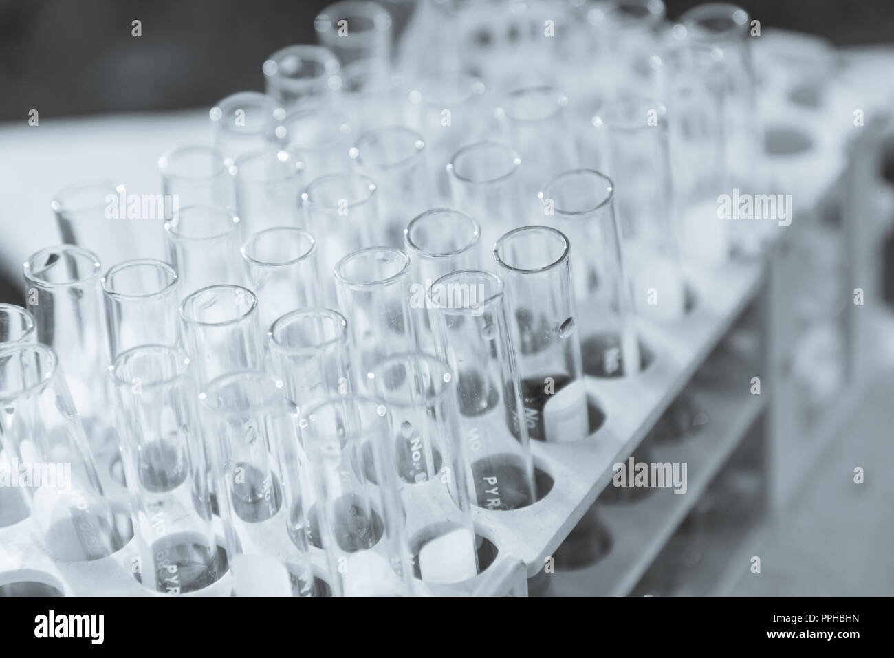 Lab science research glass items adding drop to one of several test ...