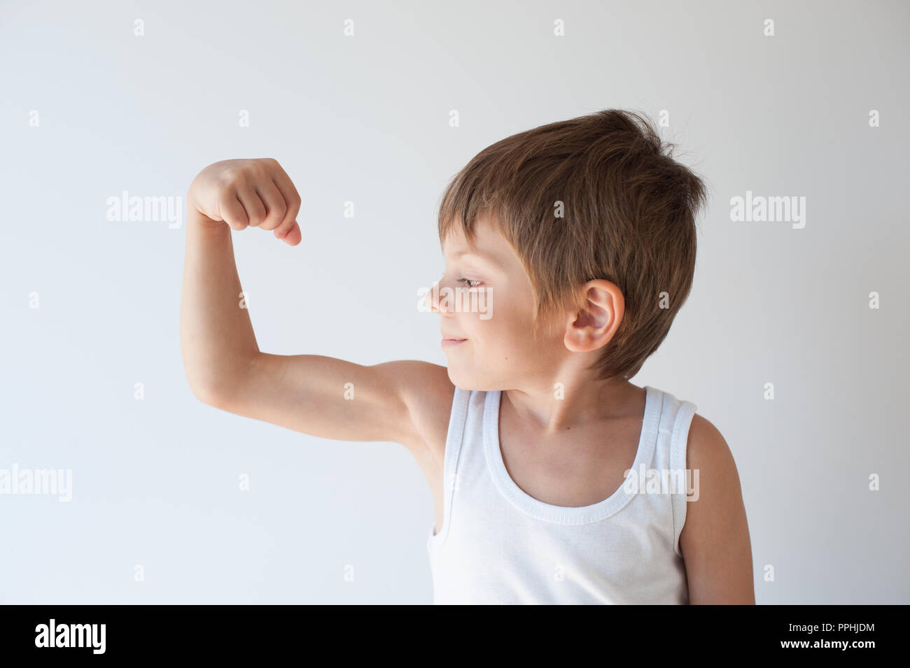 cute healthy little caucasian kid in white shirt showing his biceps ...