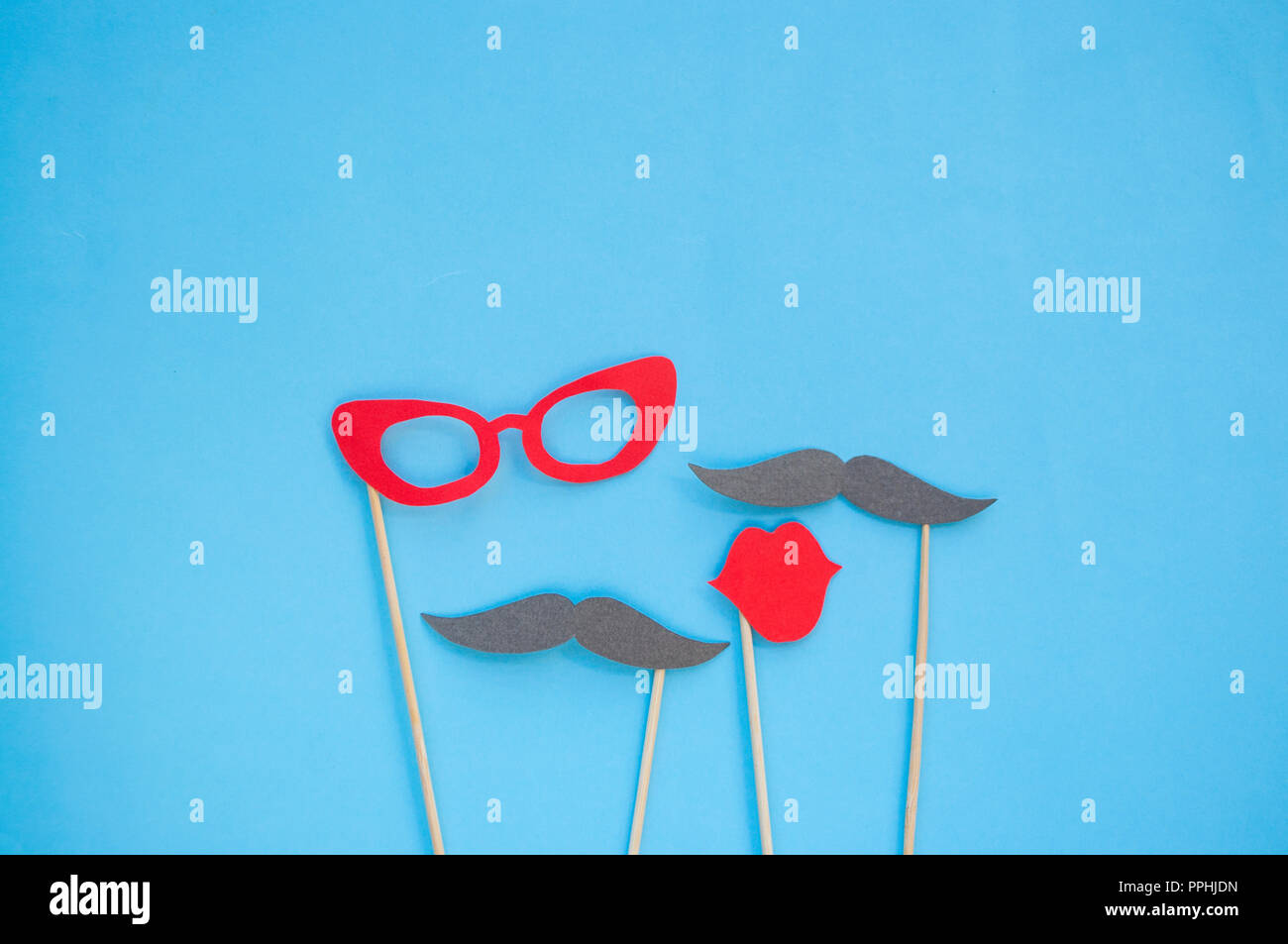 Colorful photo booth props glasses, lips and moustaches on blue ...