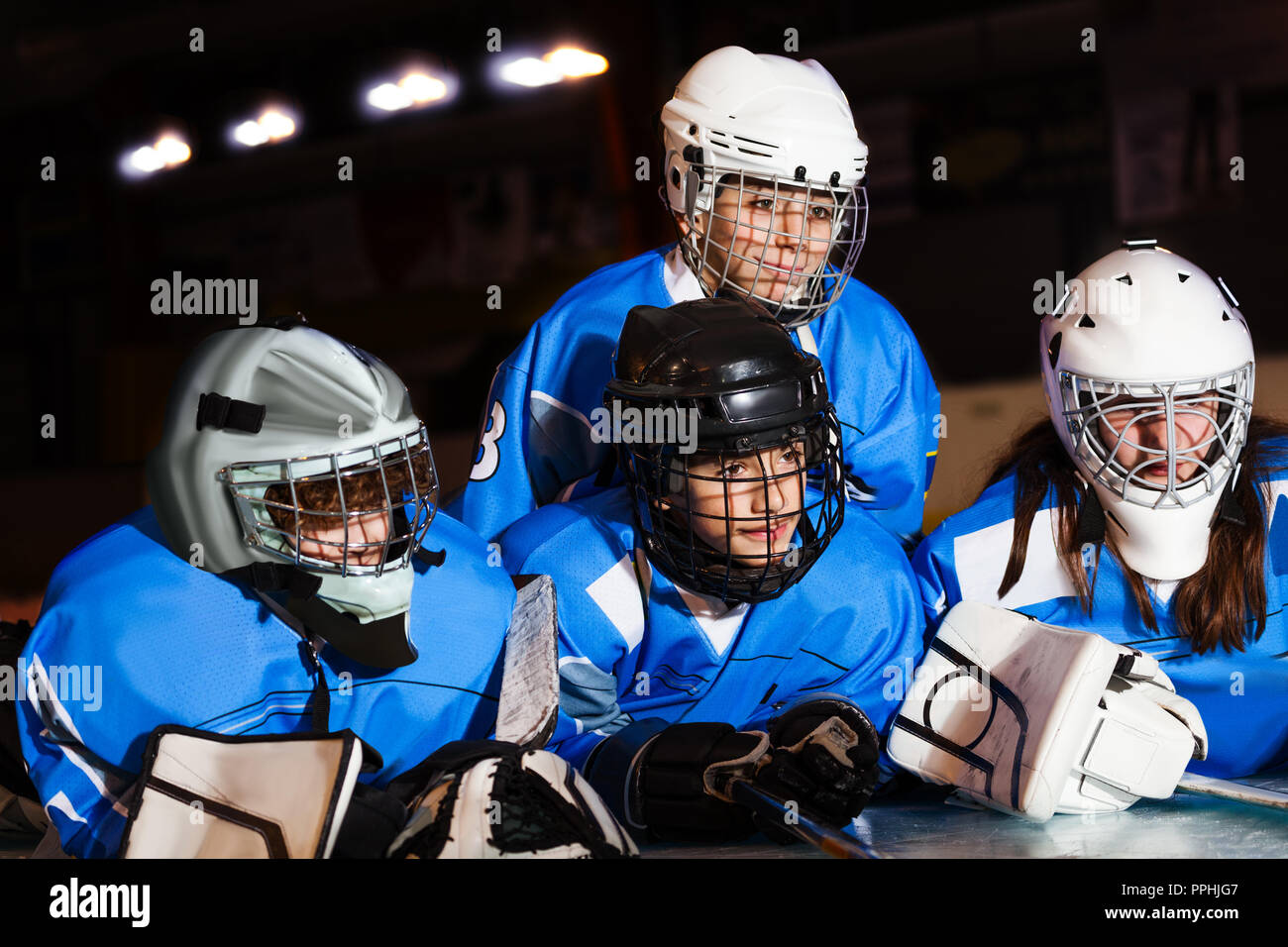Happy teenage hockey players laying on ice rink Stock Photo - Alamy