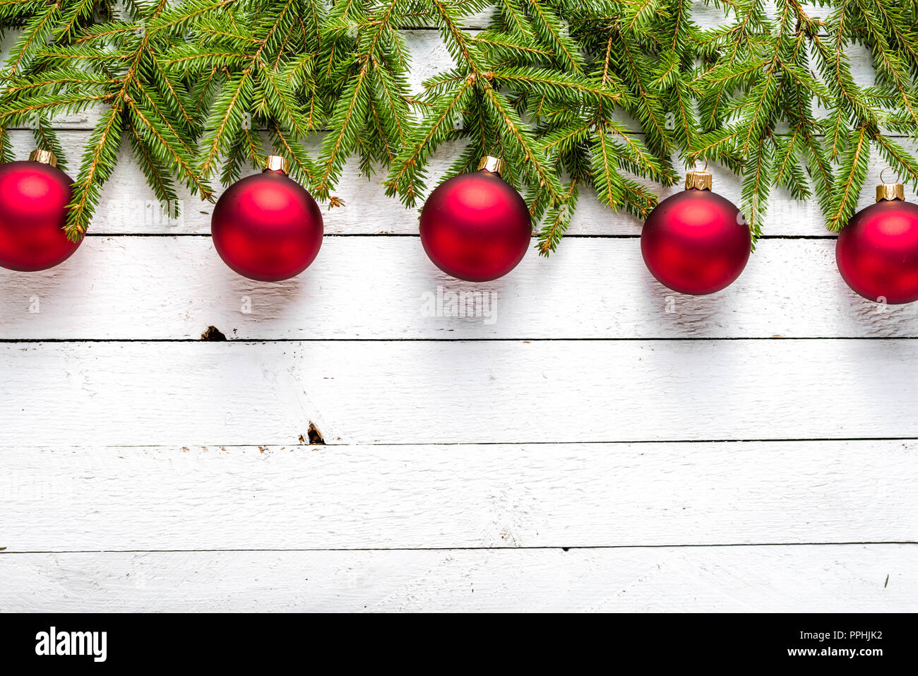 Christmas background with red balls on fir branches on wooden white ...