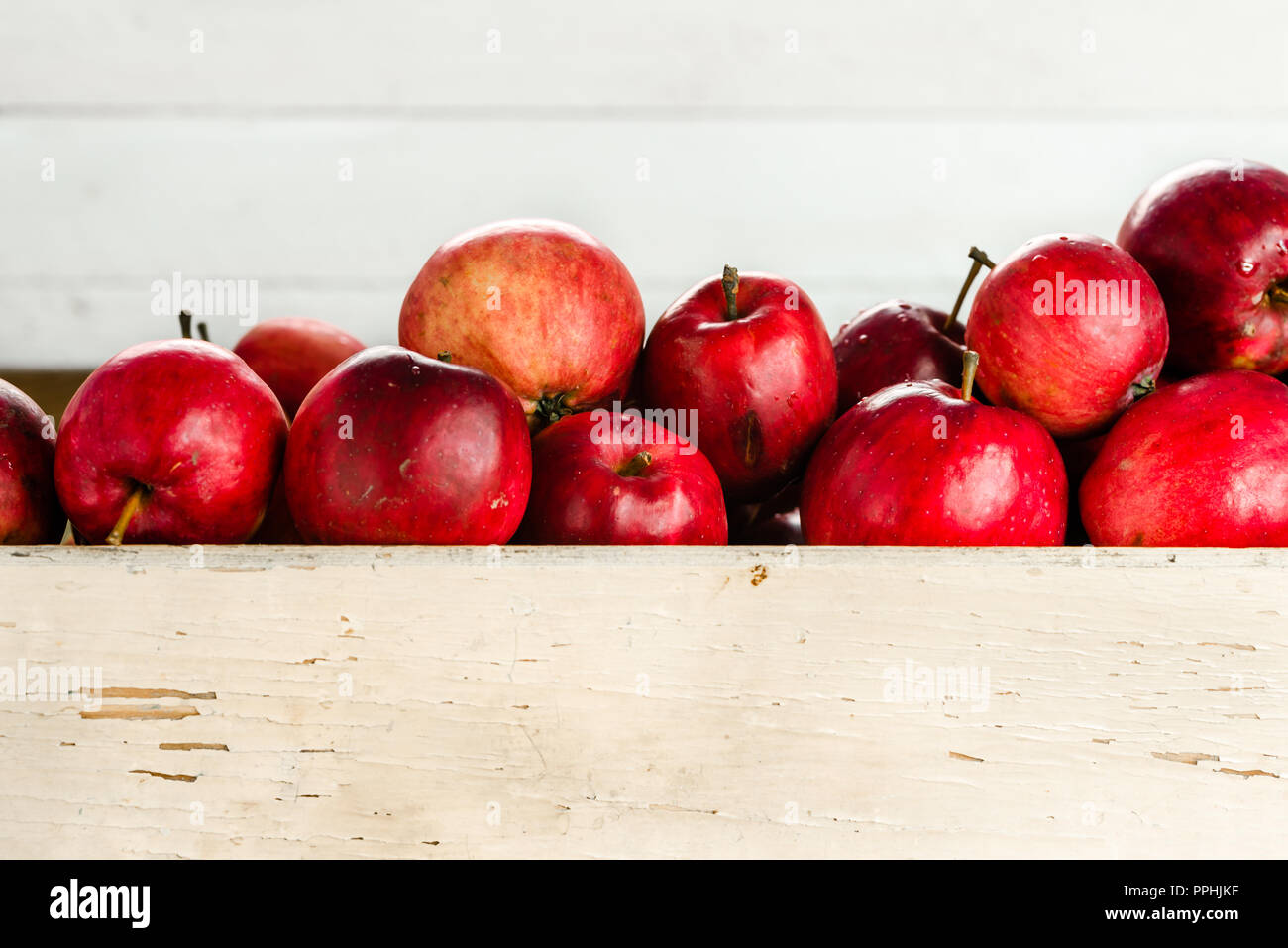 Red apples on table in wooden crate, pile of fresh apple on white ...