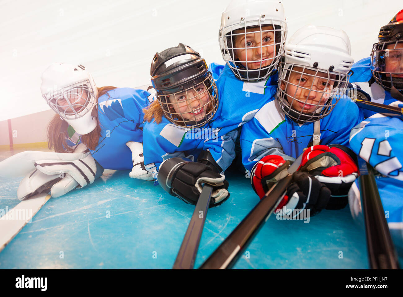 Young hockey players with sticks laying on ice Stock Photo - Alamy