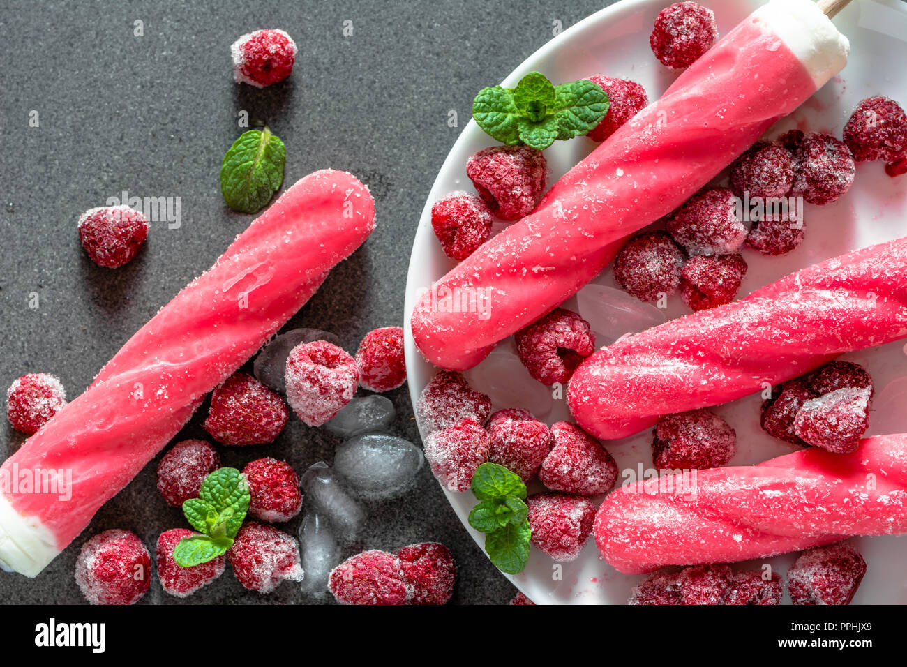 Popsicle on ice and frozen raspberry fruits Stock Photo - Alamy
