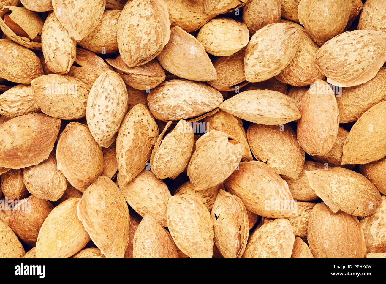 fresh raw unpeeled almonds nuts, food background Stock Photo - Alamy