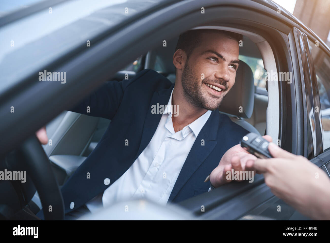 Car dealership.Young man receiving car key from saleswoman Stock Photo ...