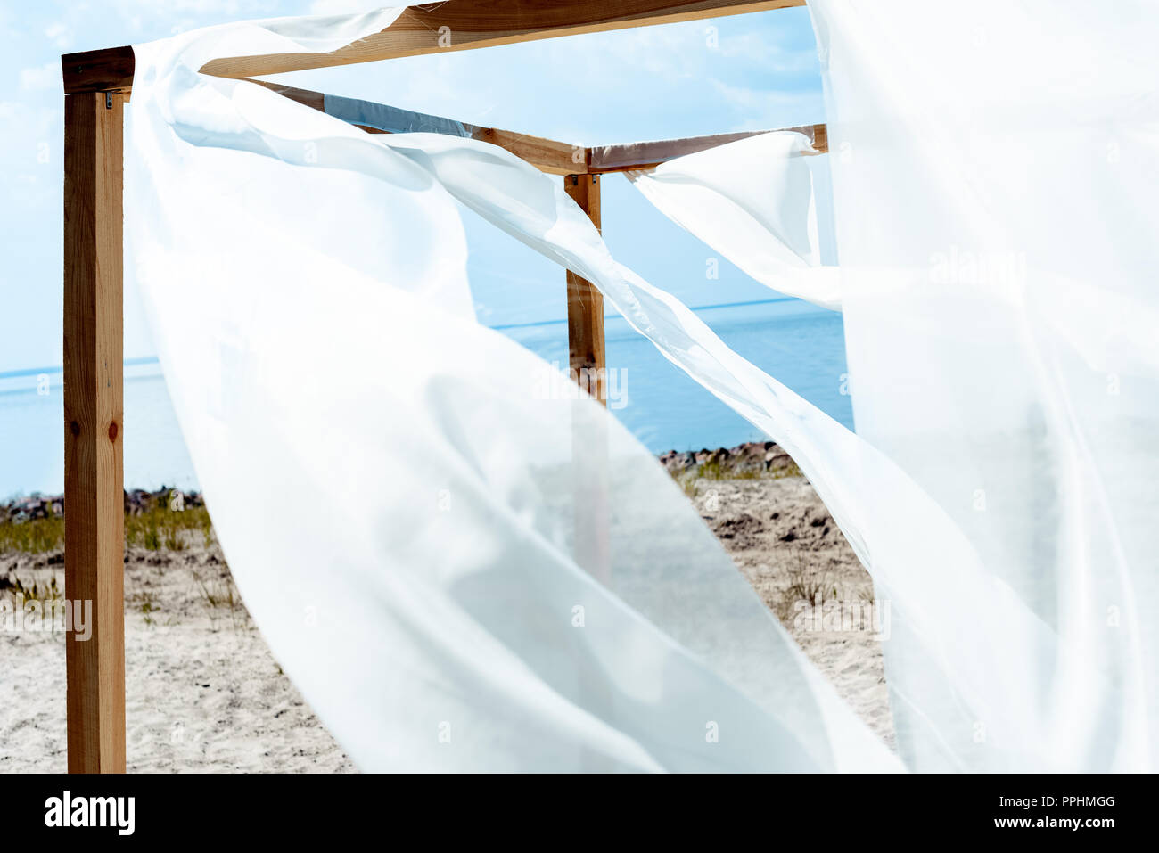 close up view of wooden decoration with white curtain lace, blue cloudy ...