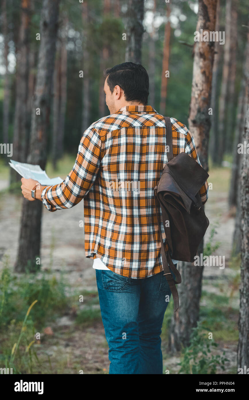 back view of tourist with map and backpack in forest Stock Photo - Alamy