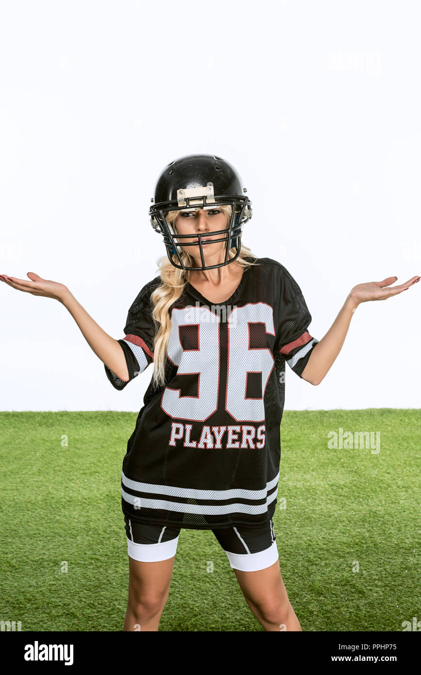 bewildered young woman in american football equipment gesturing ...