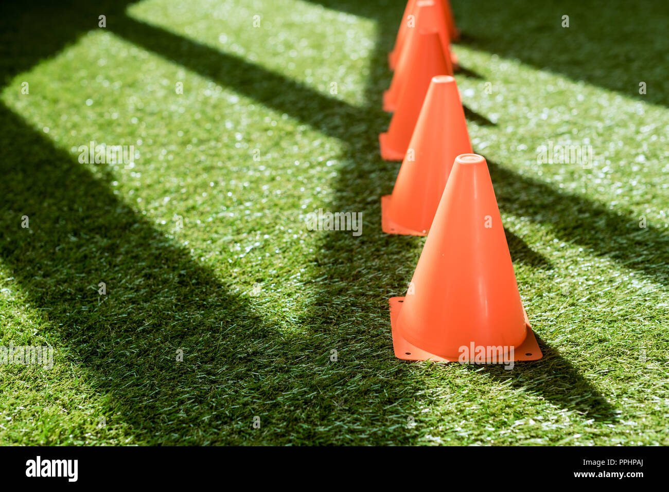 close-up shot of row of safety cones standing on green grass Stock ...