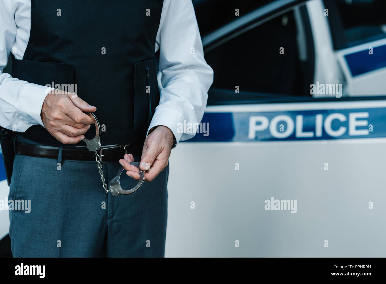 Police officer holding handcuffs hi-res stock photography and images ...