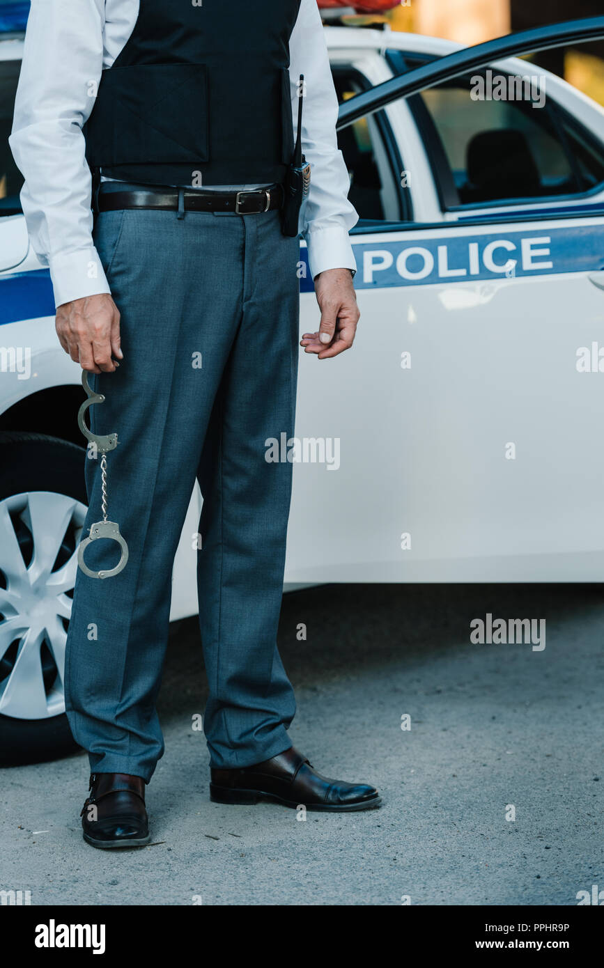 Police officer holding handcuffs hi-res stock photography and images ...