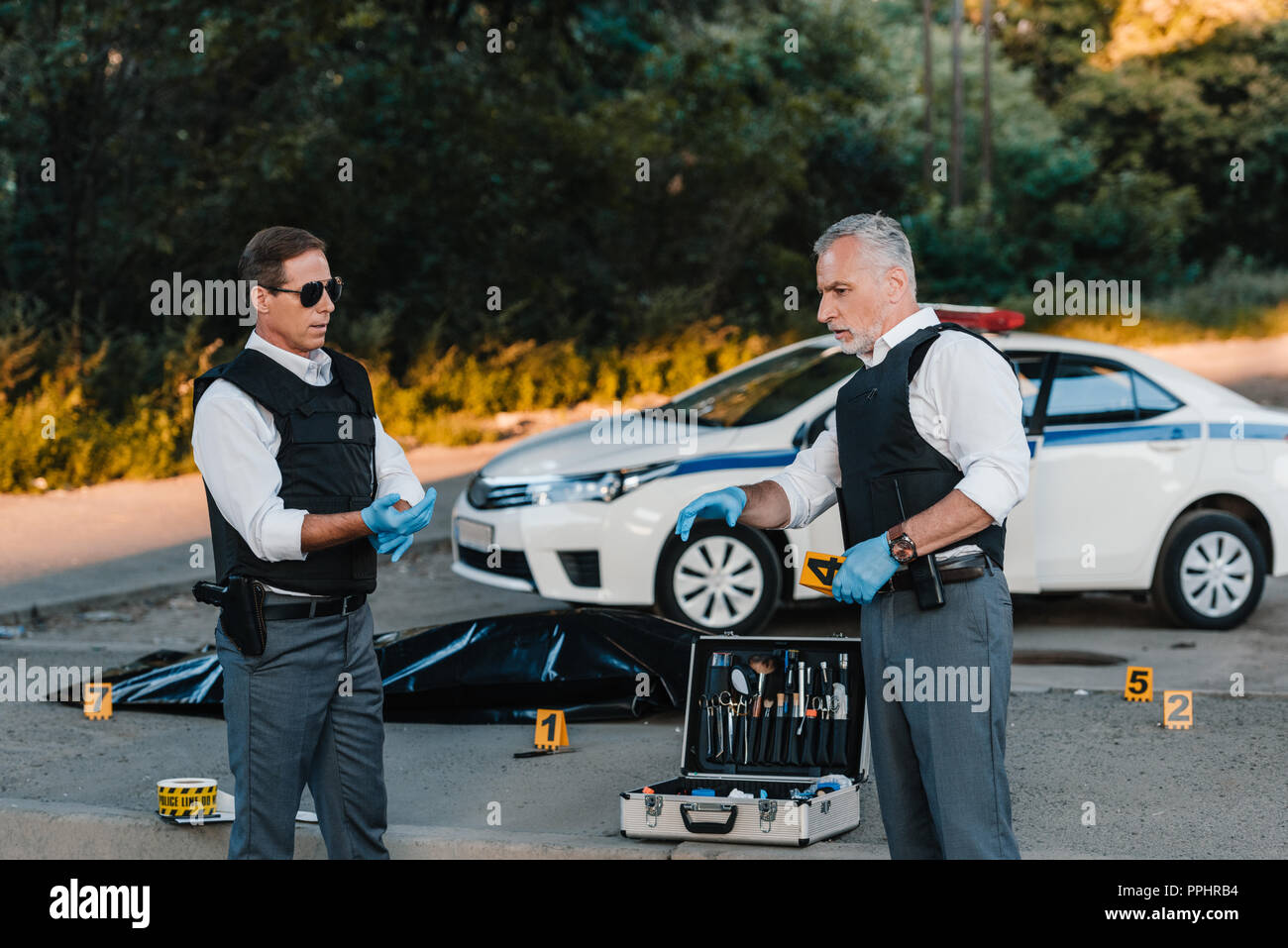male police officer in latex gloves pointing by finger to colleague in ...