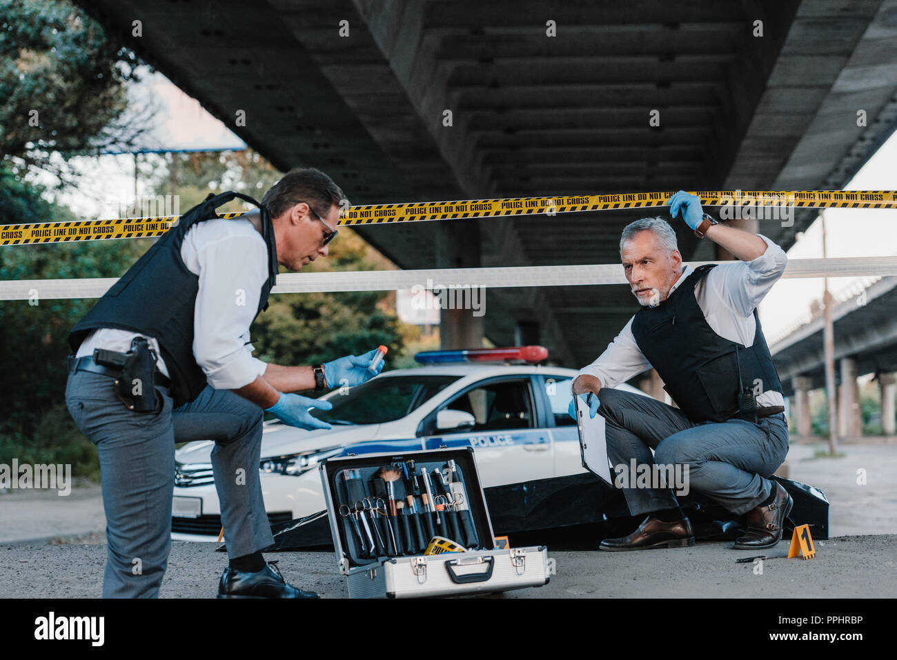 middle aged policeman holding police line above head and talking to ...