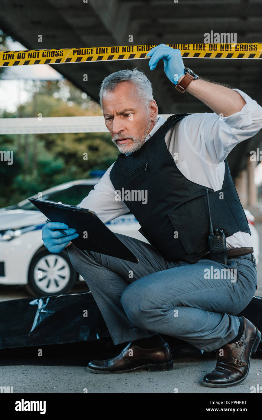 male police officer in latex gloves holding police line above head and ...