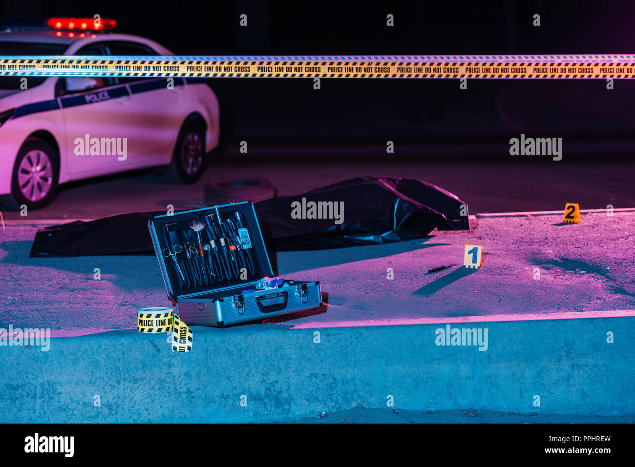 toned picture of case with investigation tools, cross line, police car ...