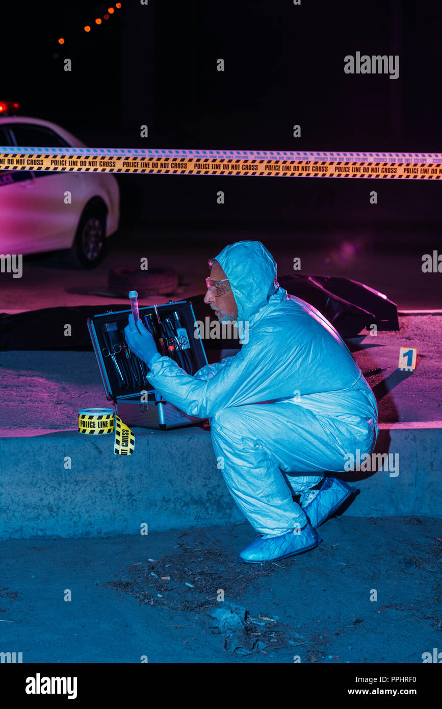 Side View Of Focused Male Criminologist In Protective Suit And Latex