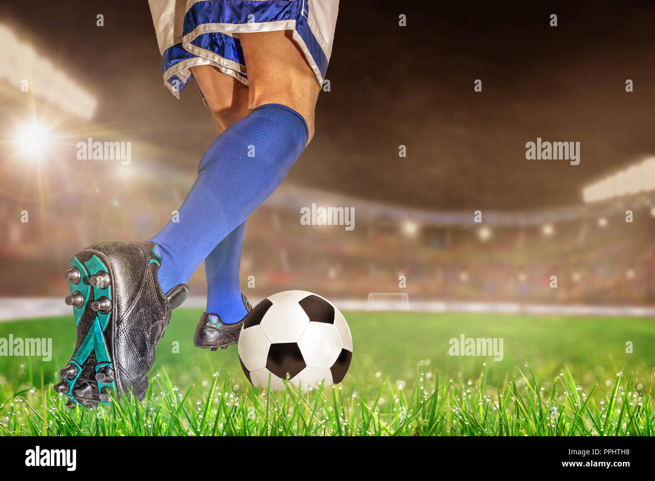 Soccer player in action with football in brightly lit outdoor stadium ...