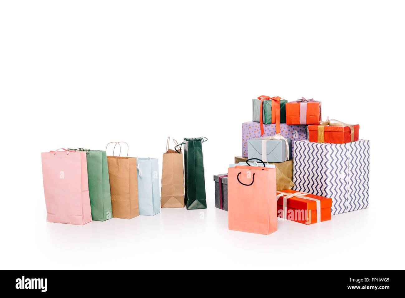 colorful shopping bags and various stacked gift boxes isolated on white ...
